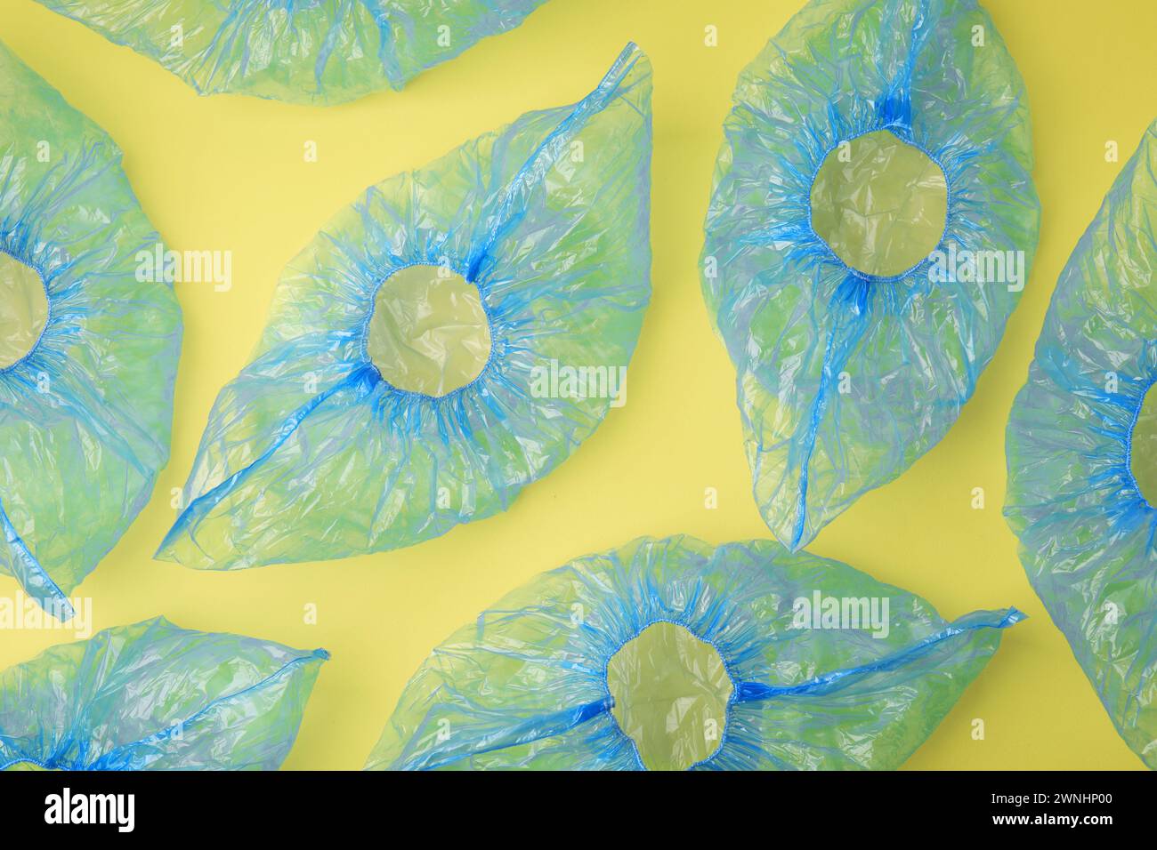 Blue medical shoe covers on yellow background, flat lay Stock Photo - Alamy