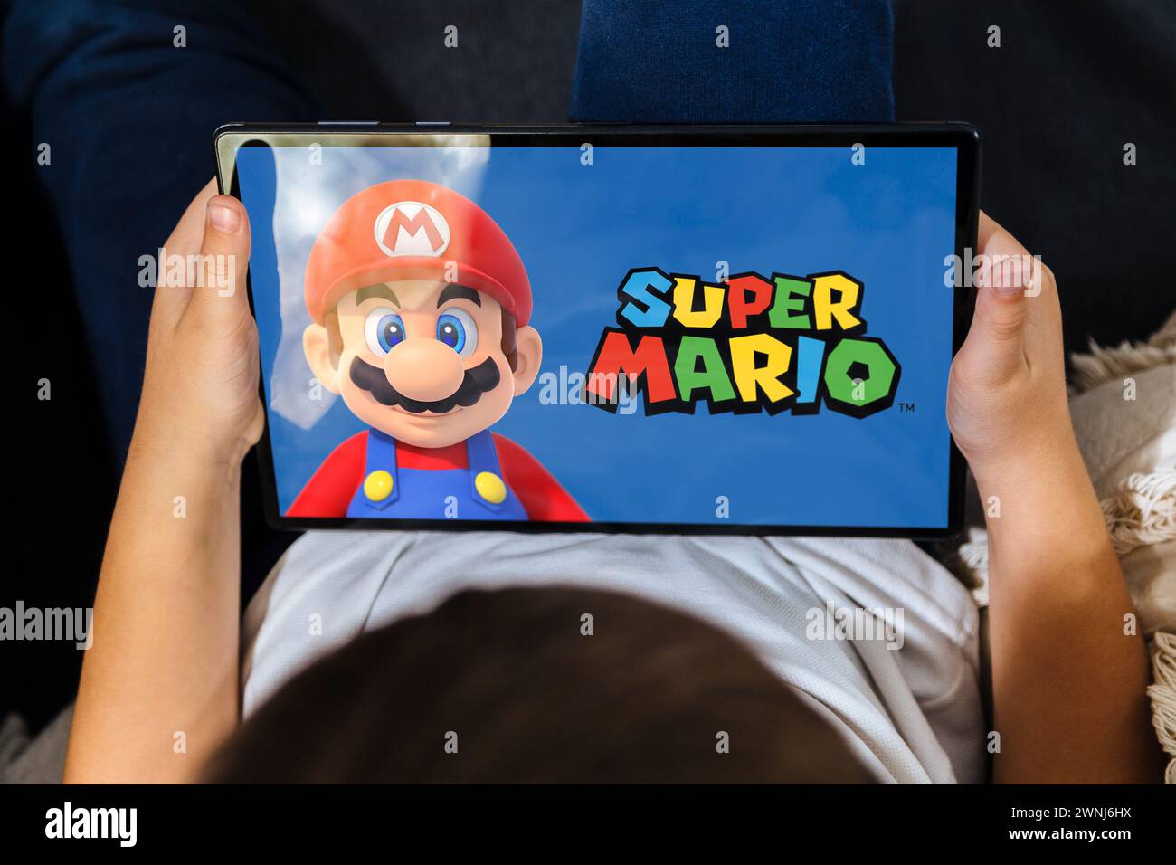 Boy playing Mario Bros on a tablet. This is a very popular and classic ...