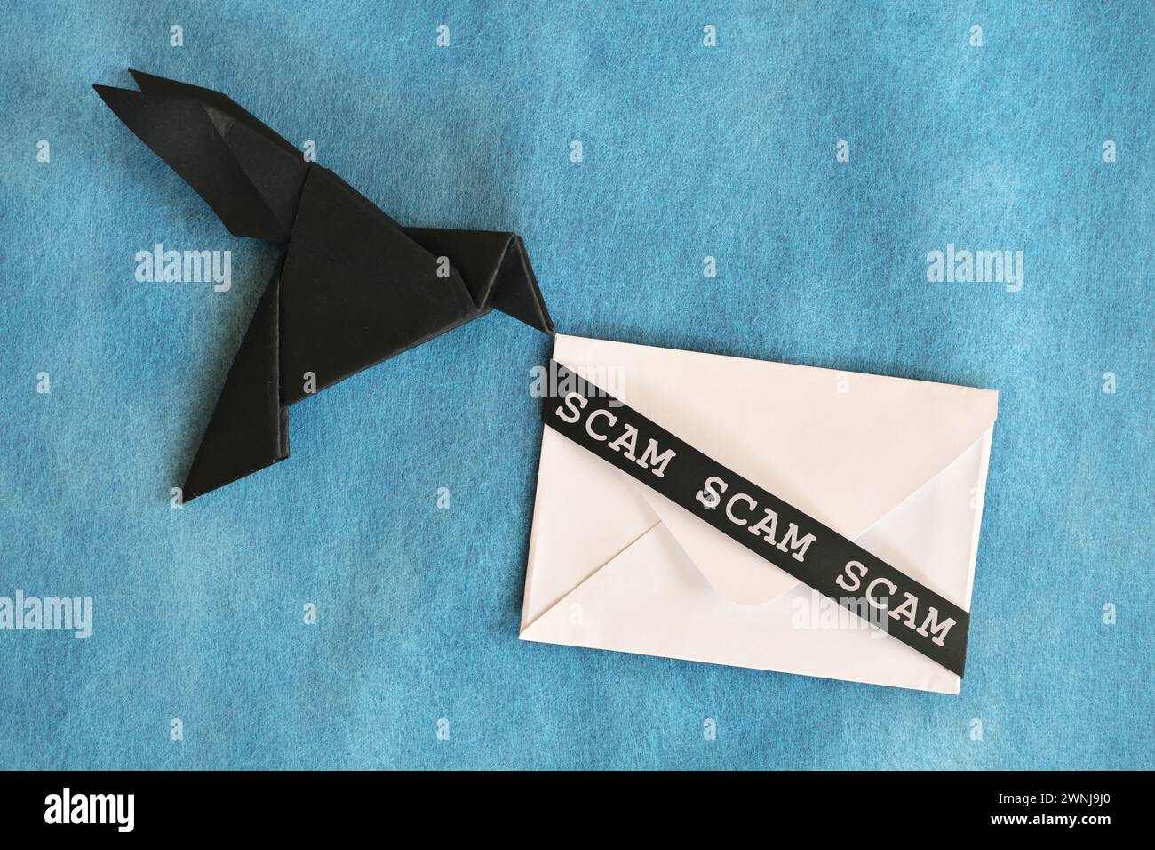 Black raven paper origami carrying white letter envelope with word scam ...