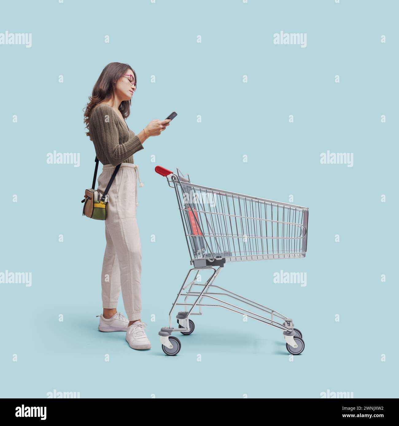 Young woman doing grocery shopping, she is standing behind a shopping ...