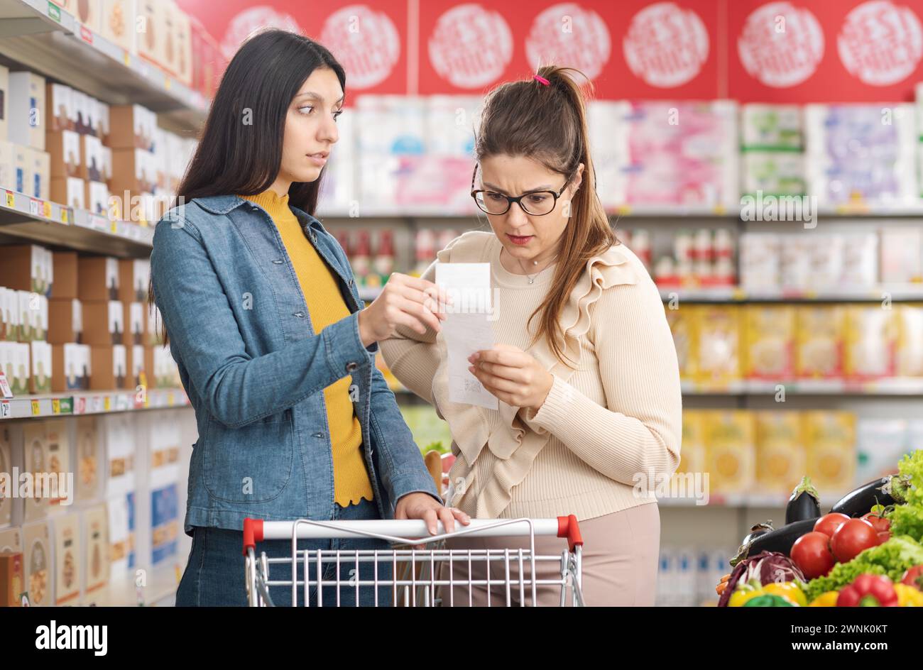 Disappointed women at the supermarket, they are checking an expensive ...