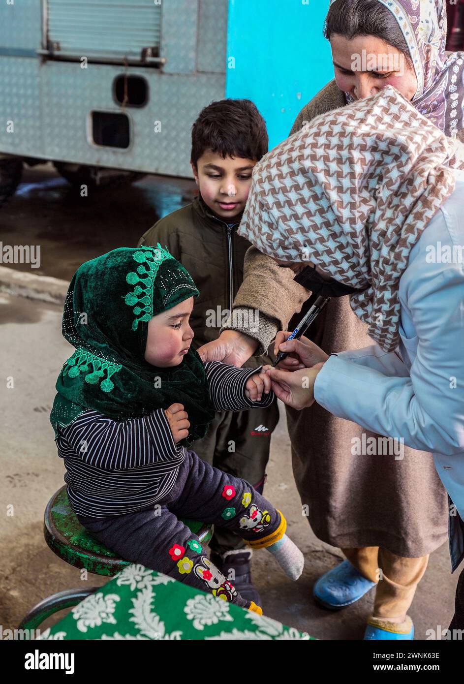 A government health worker puts a mark on a child's finger after ...