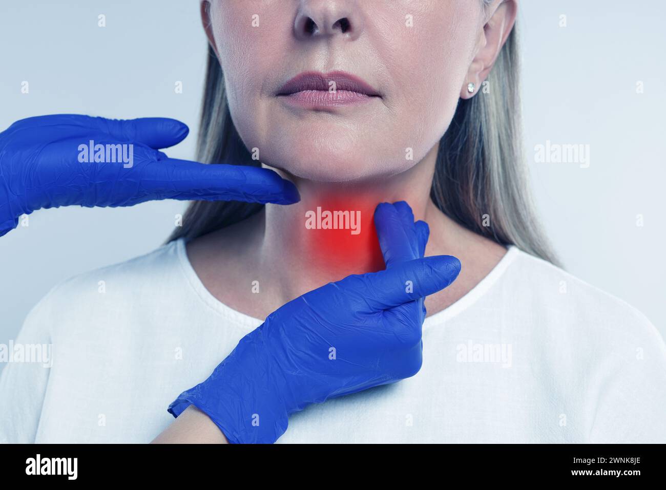 Endocrinologist examining thyroid gland of patient on light grey ...