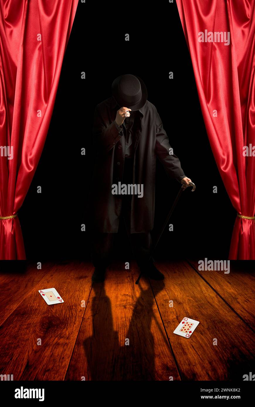 a magician with hat and walking stick on a stage, playing cards on the ...