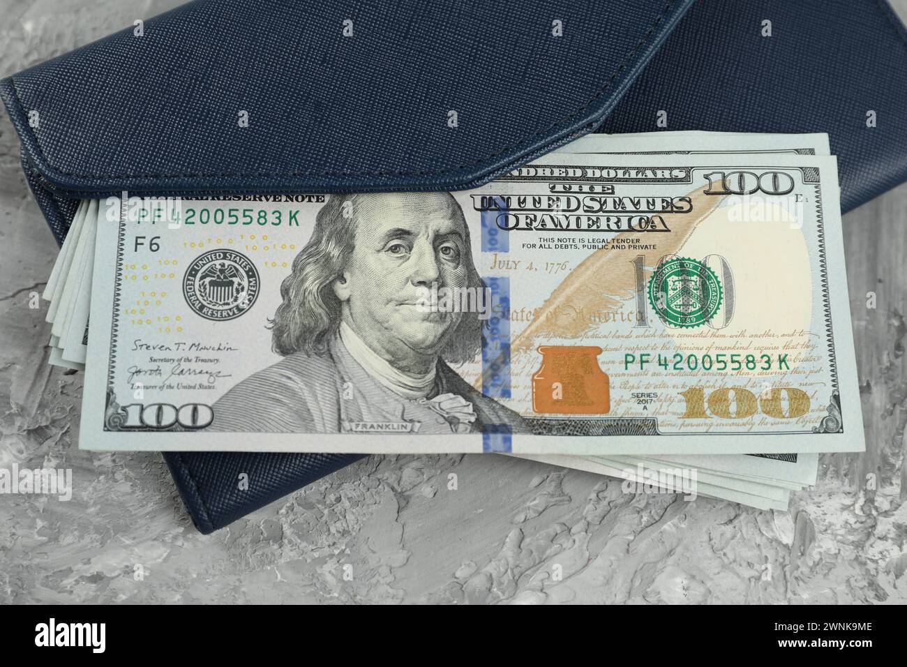 Money exchange. Wallet with dollar banknotes on grey stone background ...