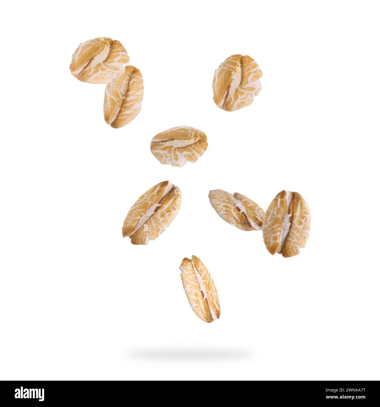 Rolled oat flakes falling on white background Stock Photo - Alamy
