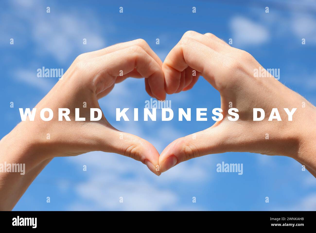 World Kindness Day. Woman showing heart gesture with hands against blue ...