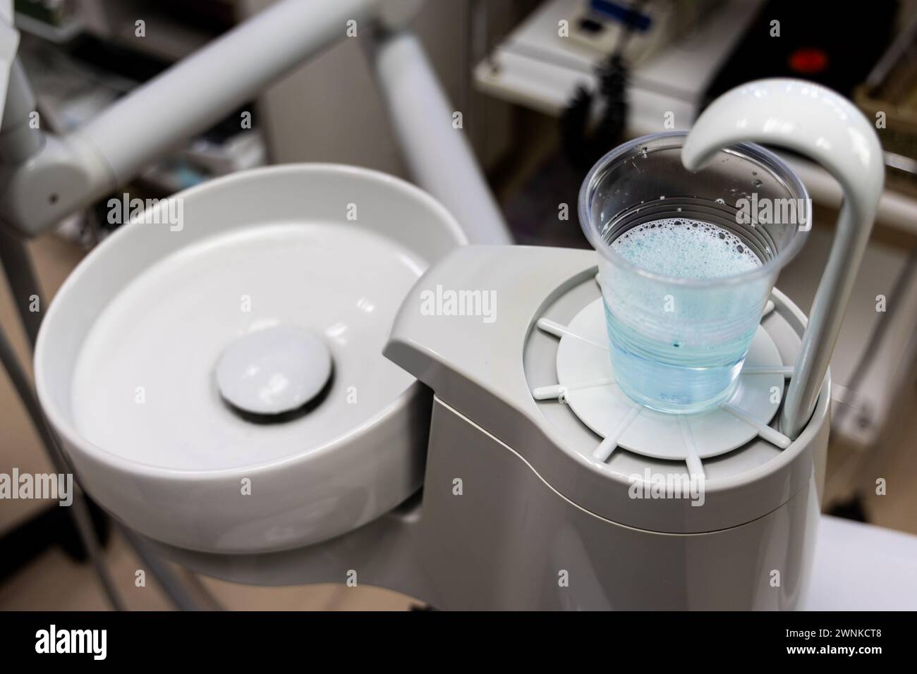 Disposable glass filled with CHX mouth rinse next to spiotoon bowl in ...