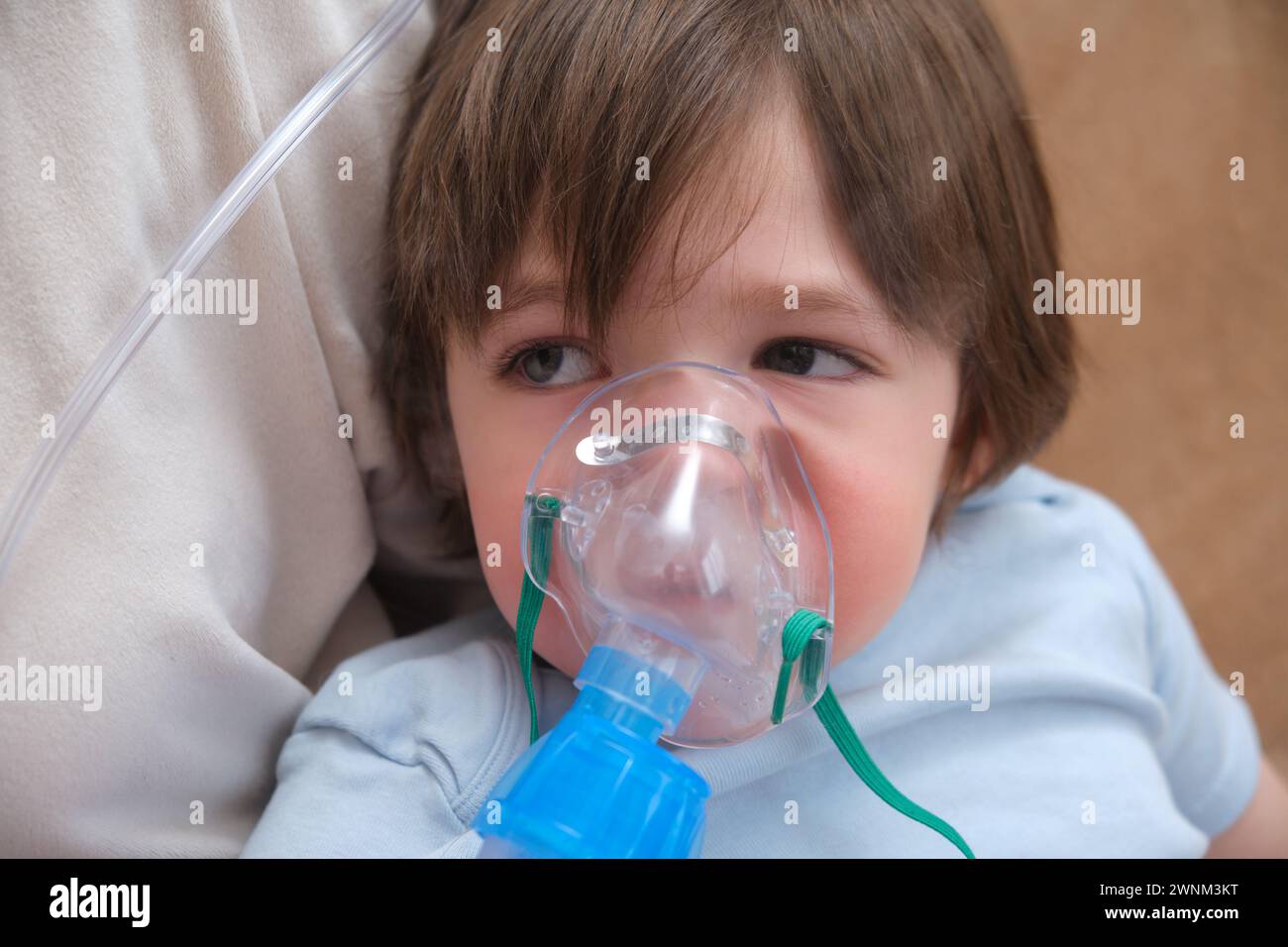 A mother woman with an inhaler helps her child cope with the disease ...