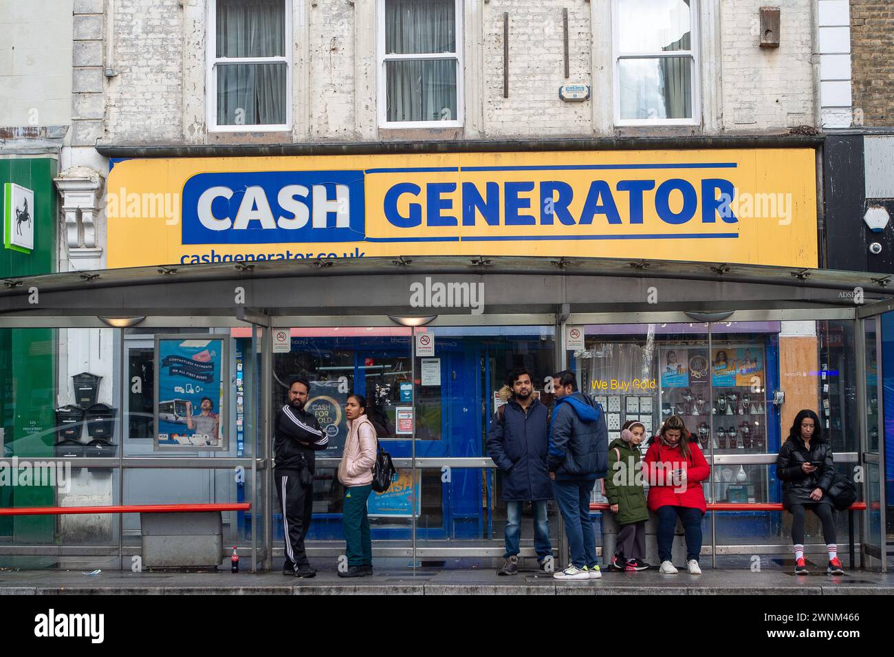 Slough, Berkshire, UK. 2nd March, 2024. People wait for a bus outside a ...