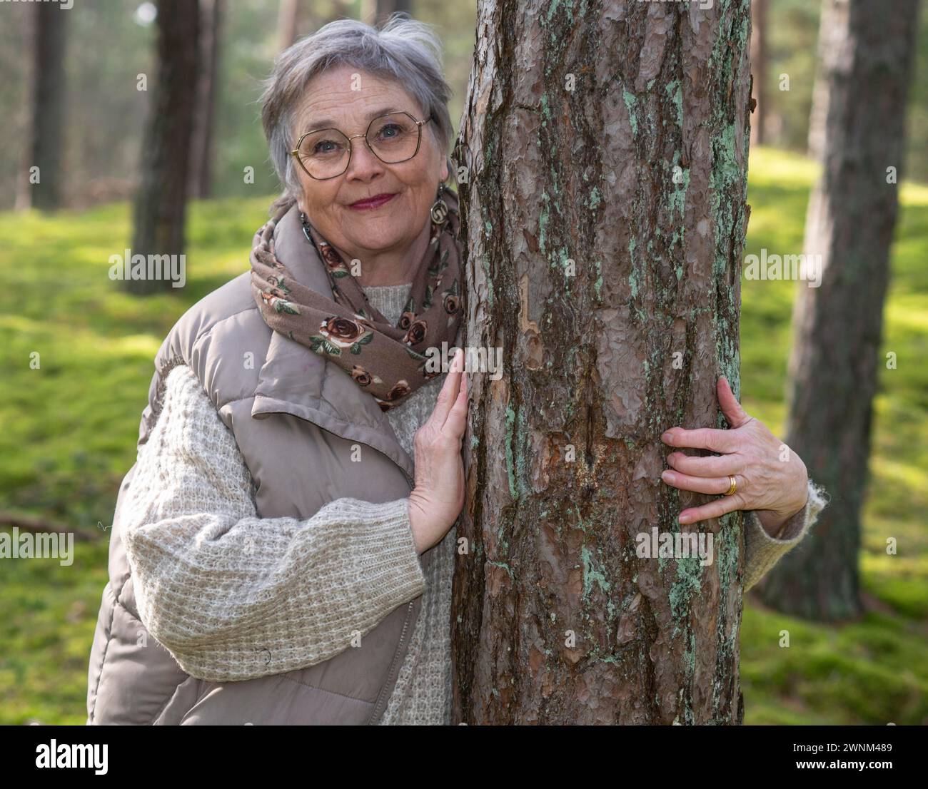 Portrait of elderly woman, 65 years old, enjoying nature in the forest ...