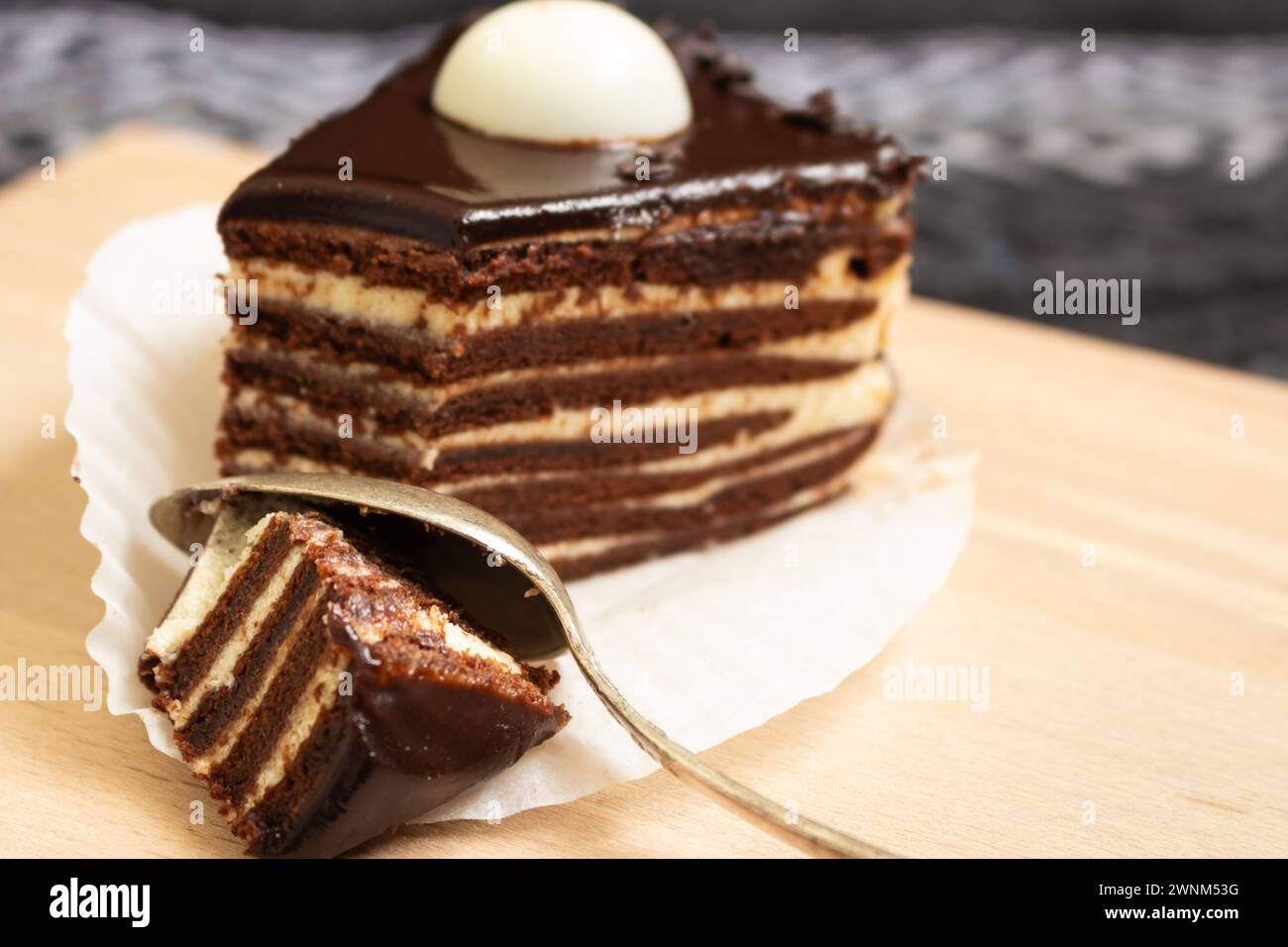 Chocolate layer cake with spoon. Biscuit cake with melted ganache on ...