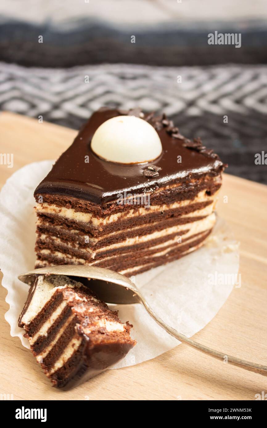 Chocolate layer cake with spoon. Biscuit cake with melted ganache on ...