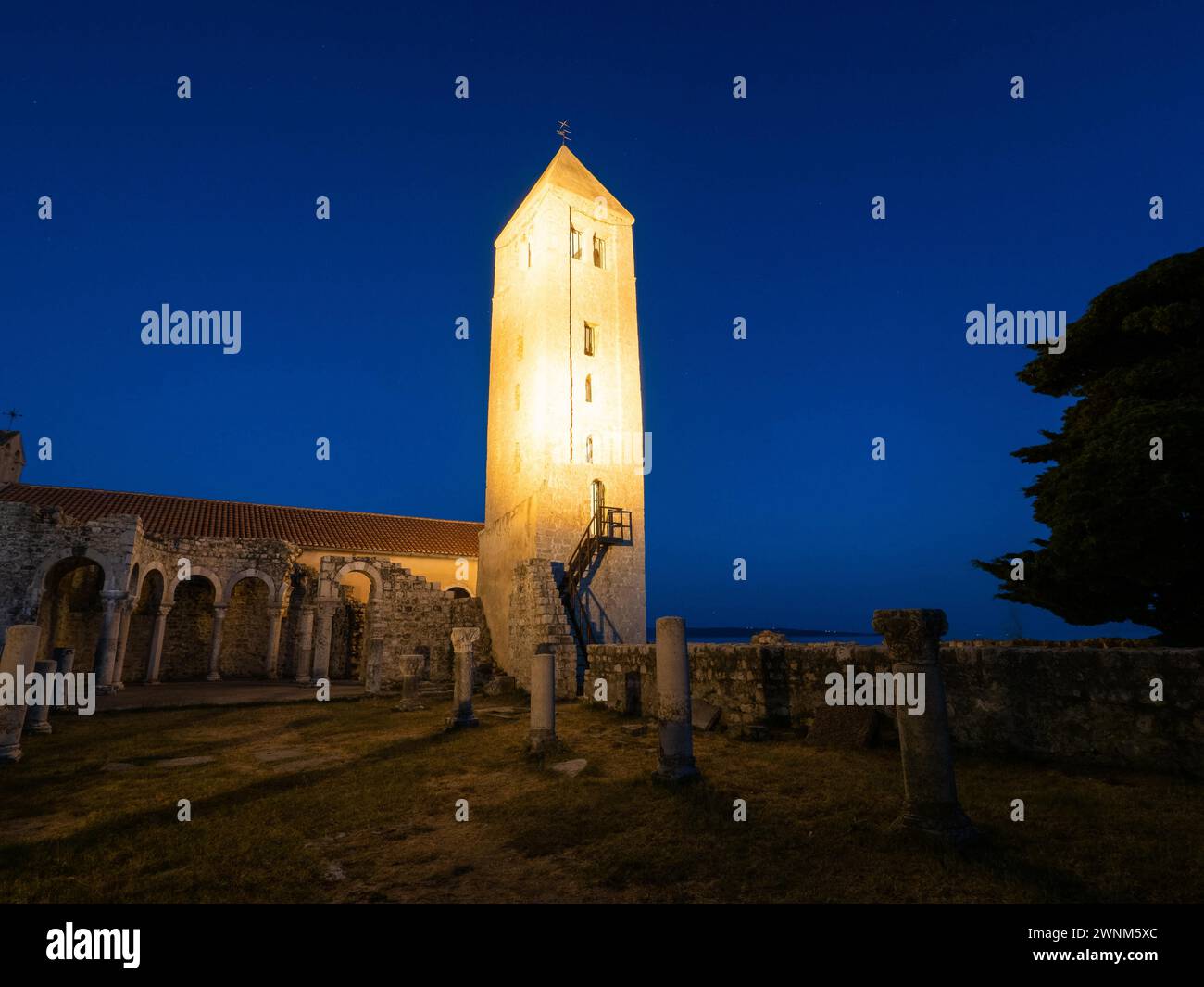 Ruins and illuminated bell tower of the Basilica of St John the ...