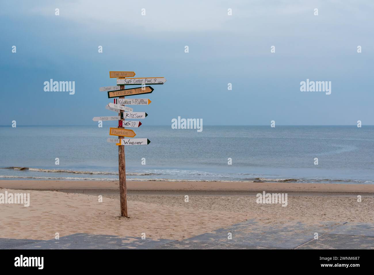 Multi-directional signposts on the beach with a view of the calm sea ...