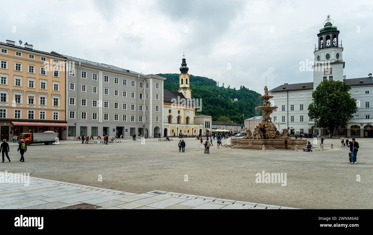 Open town square with a fountain and people, framed by classical ...