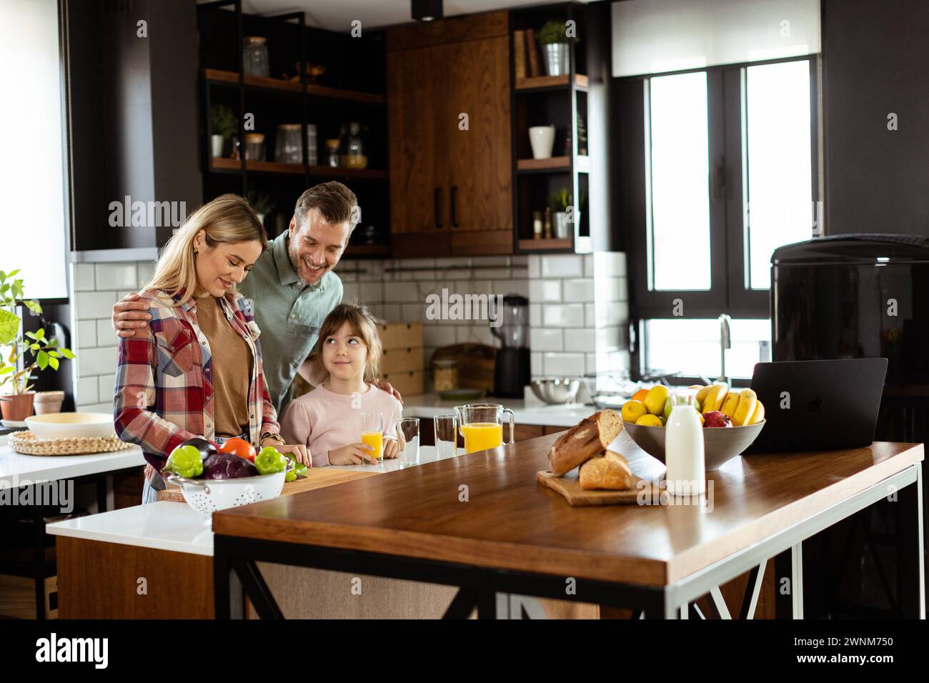Family shares a smile while preparing breakfast together in a cozy ...