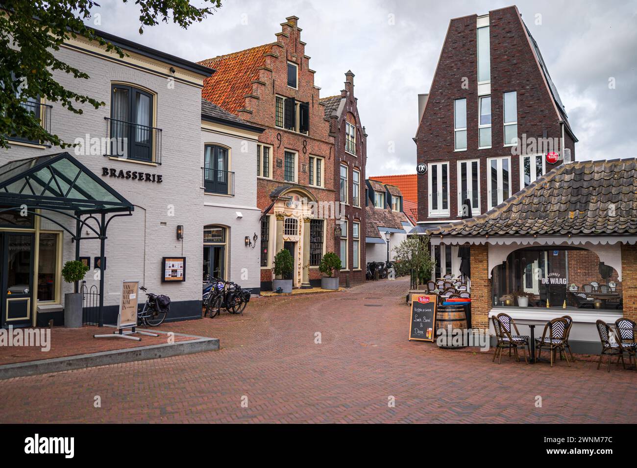 Street scene with brasserie, bicycles and traditional buildings under a ...