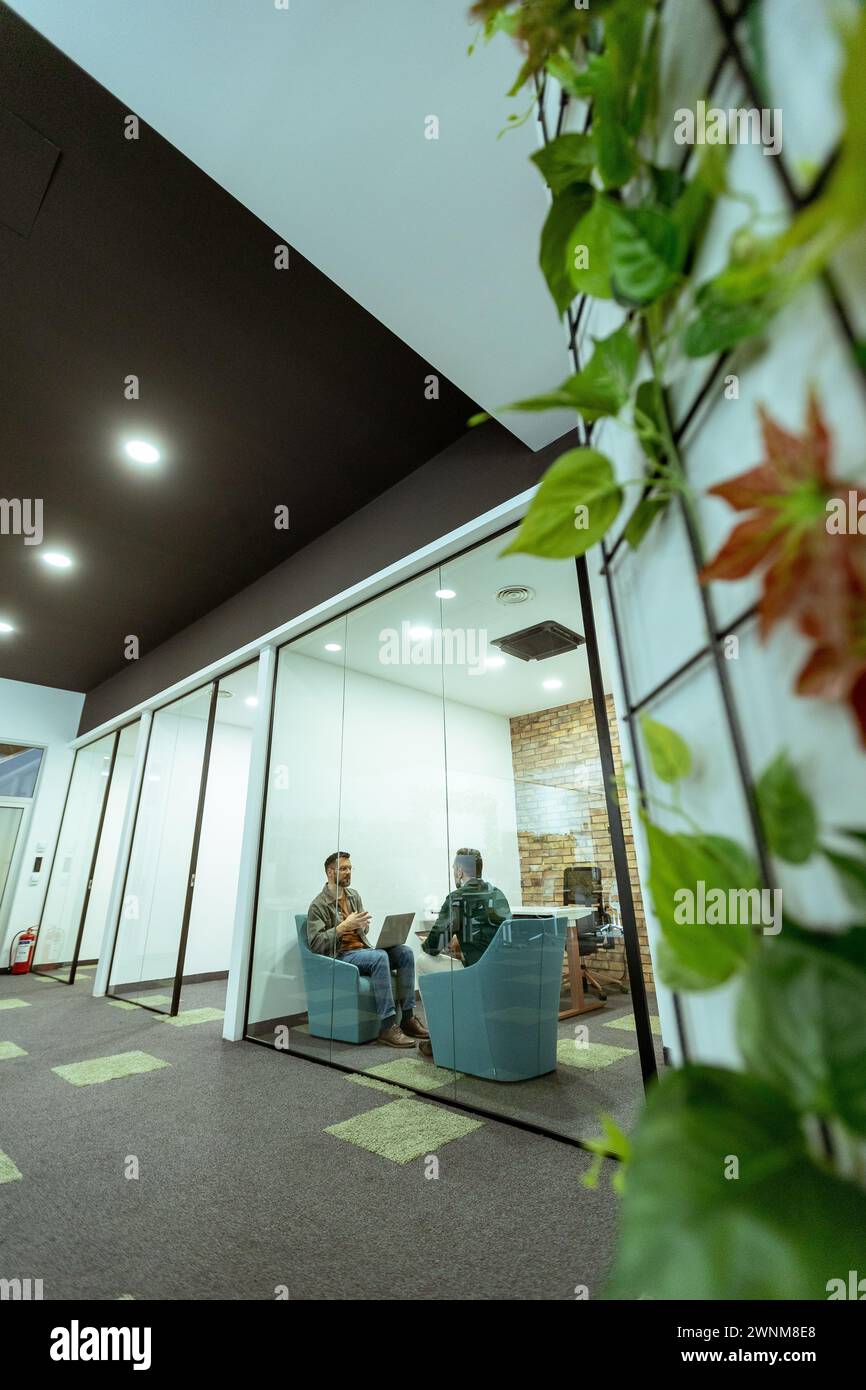 Two professionals engage in a conversation while seated comfortably in ...