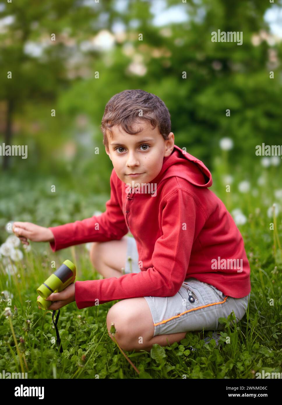 Selective focus portrait of a child sitting in grass Stock Photo - Alamy