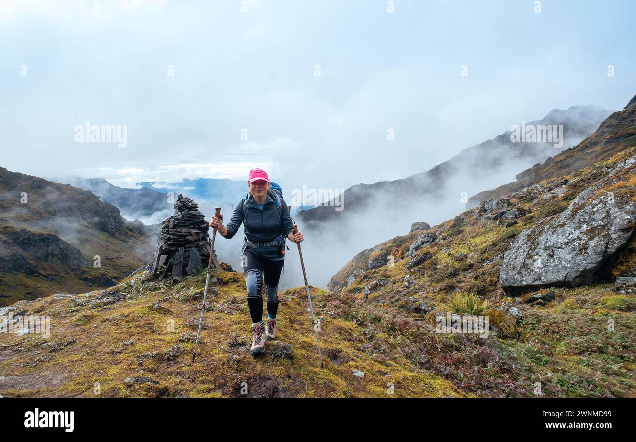 Lonely woman backpacker with trekking poles going up Zatrwa La Pass by ...