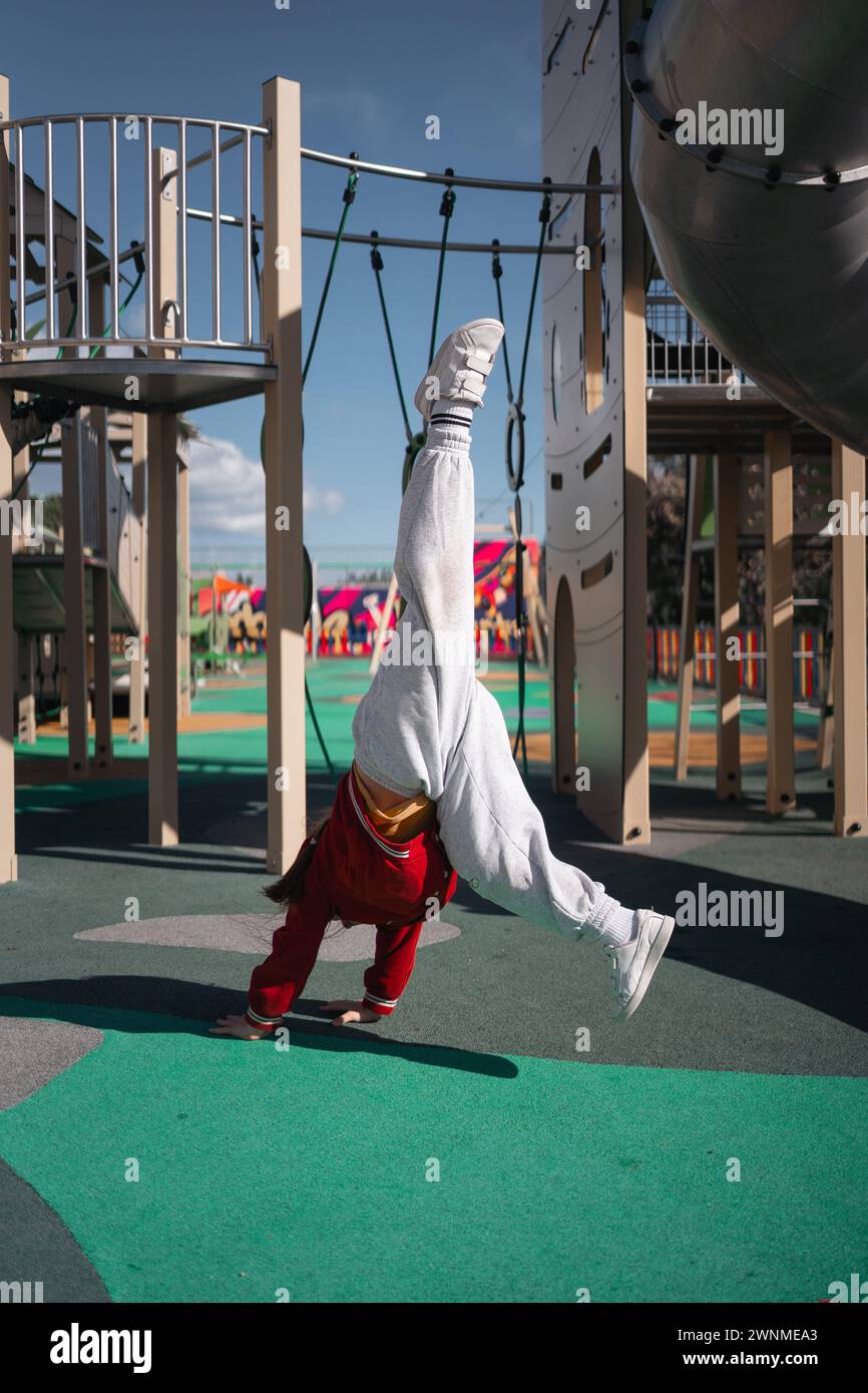 Child girl doing handstand on the outdoors playground. Funny active ...
