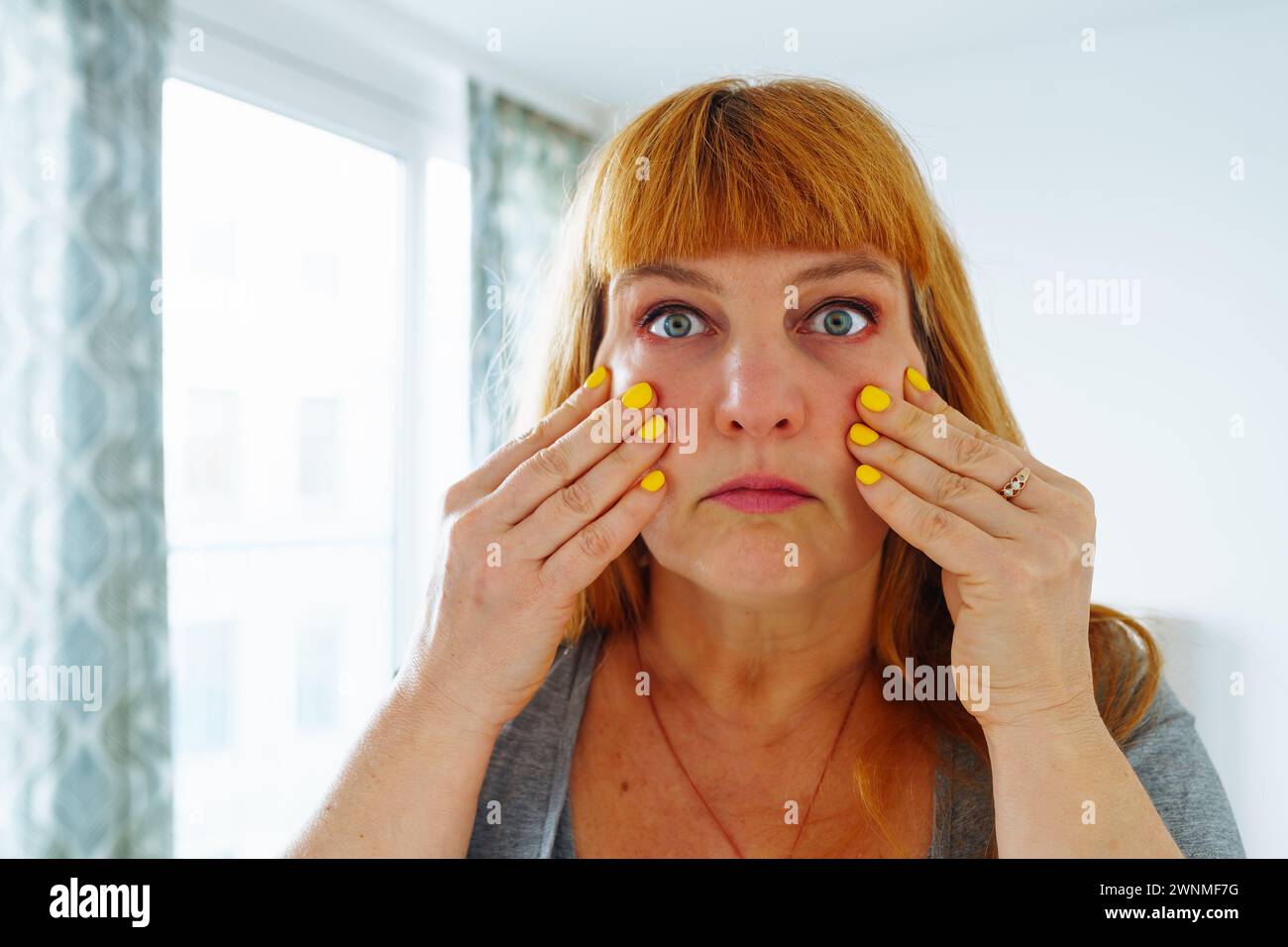 portrait middle-aged woman, red-haired, face close-up with puffy eyes ...
