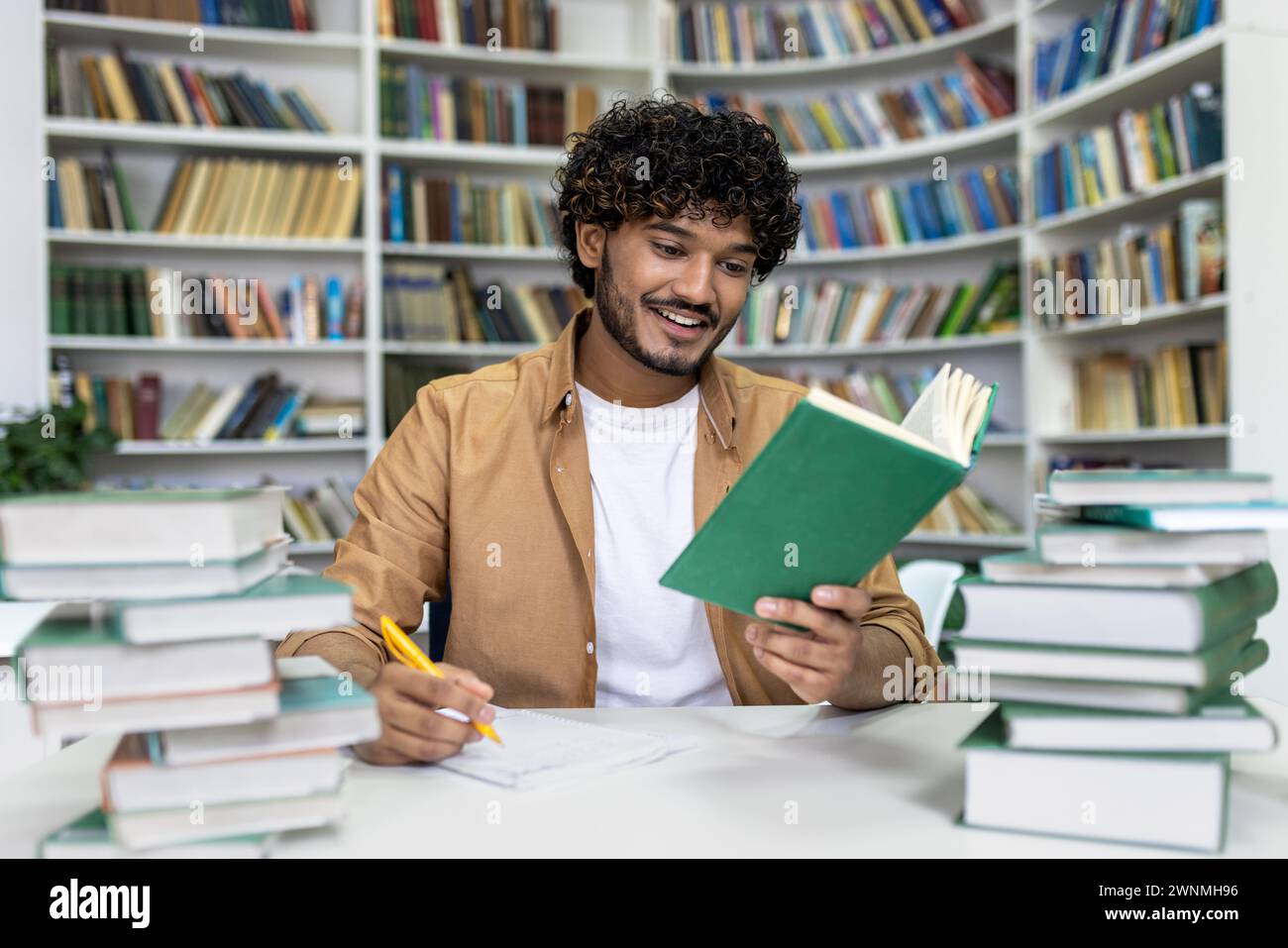 A cheerful graduate student with curly hair is immersed in exam ...