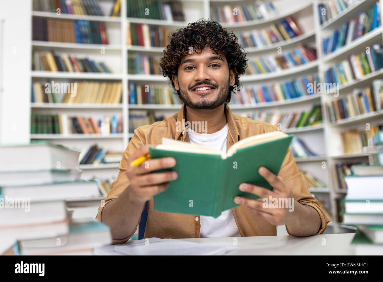 A diligent student engages in intense study at a library, with stacks ...