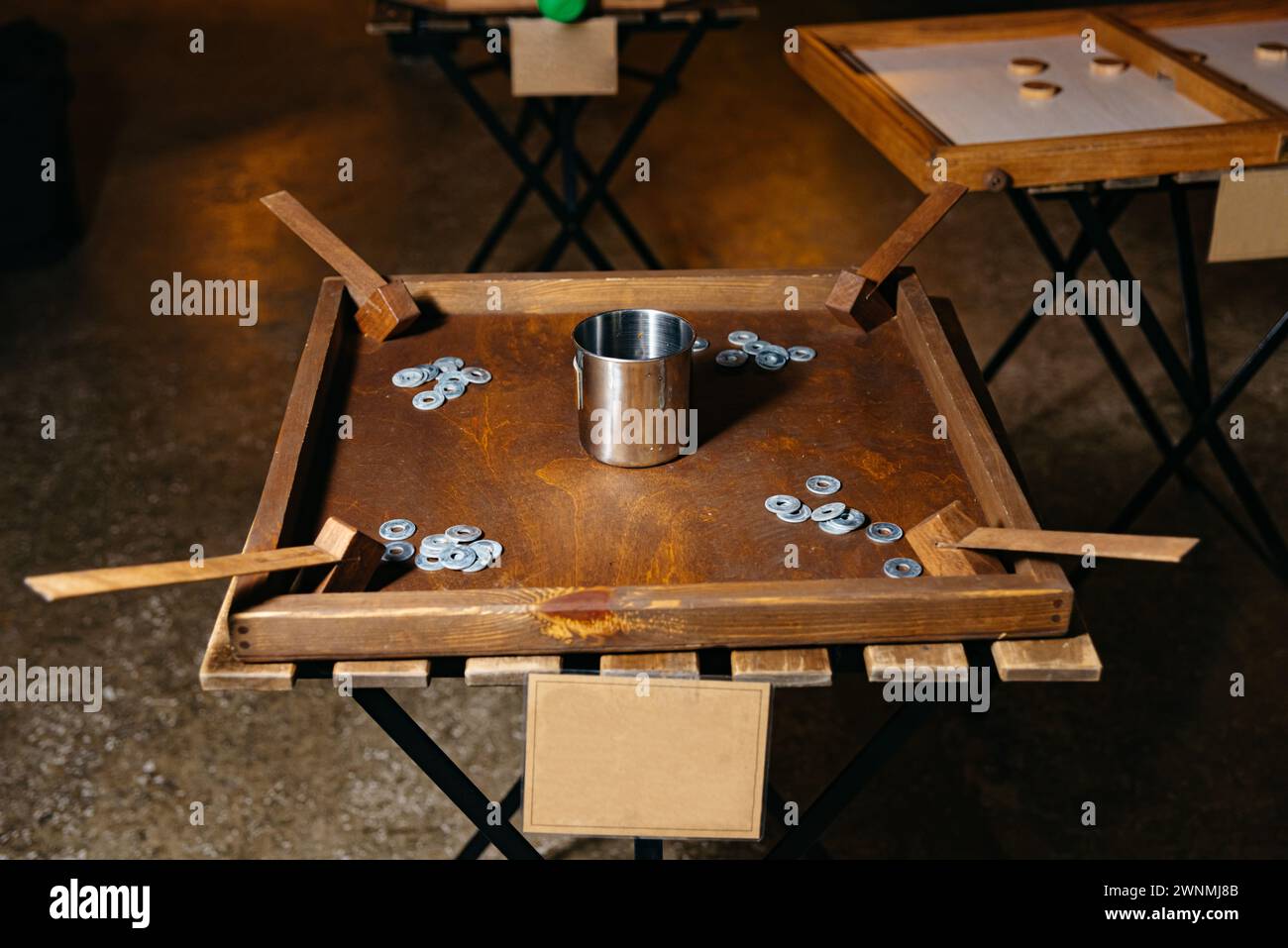 Antique wooden catapult board game setup with a central metal cup and ...