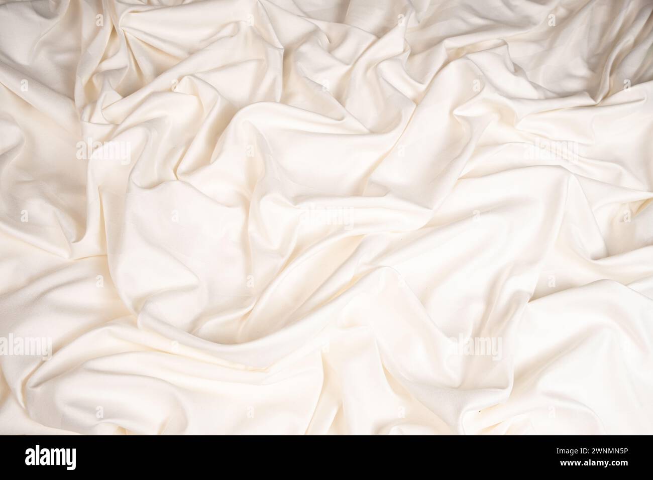 Waves and patterns of crumpled natural satin white milk color fabric ...