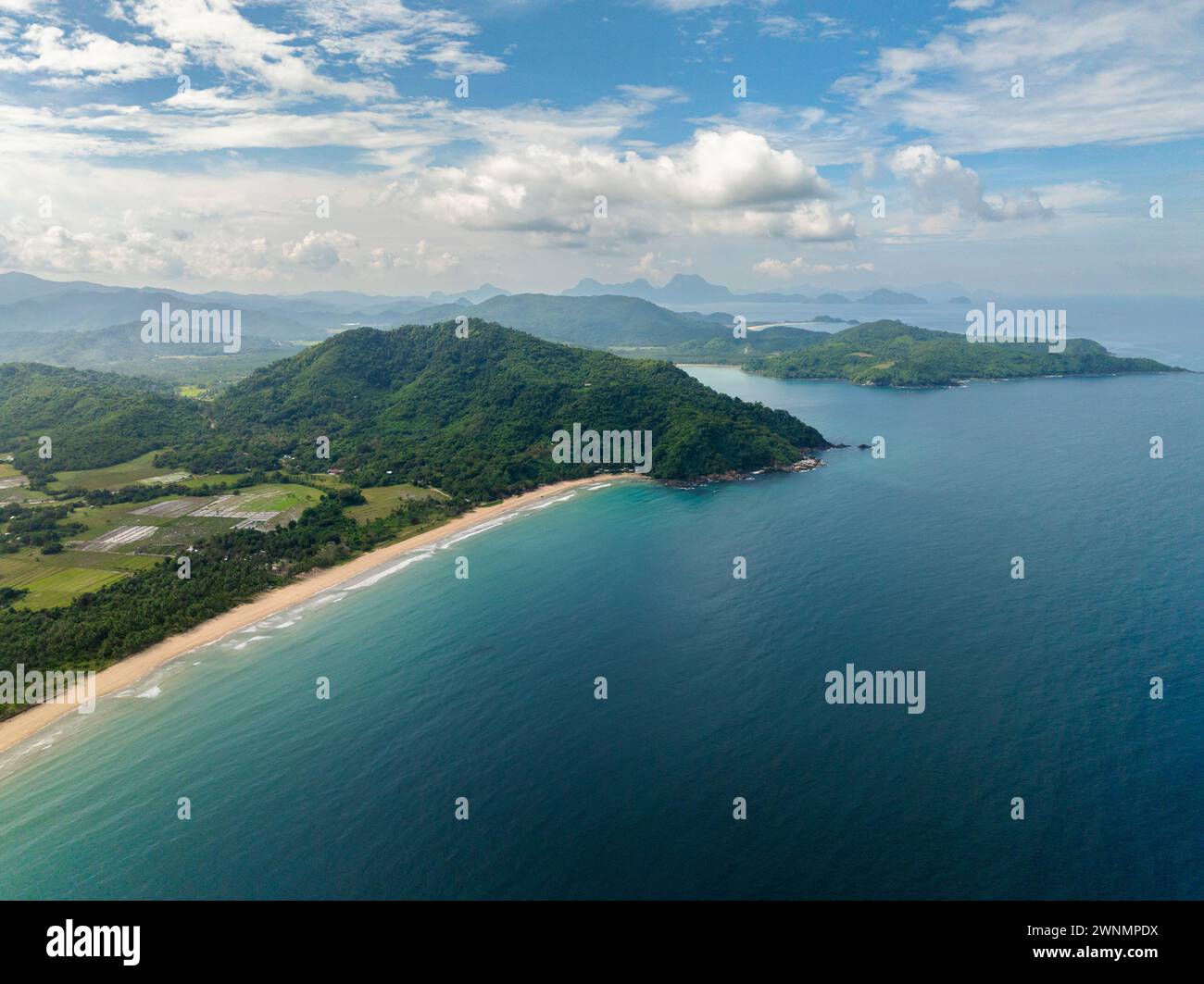 Sandy beach with inshore waves. Duli Beach. Blue sky and clouds. El ...