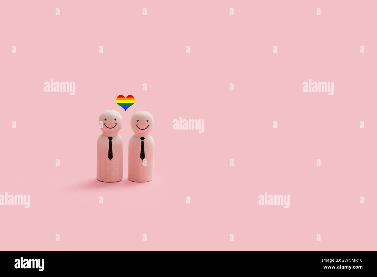 Happy wooden gay couple figures isolated on a pink background. Each ...