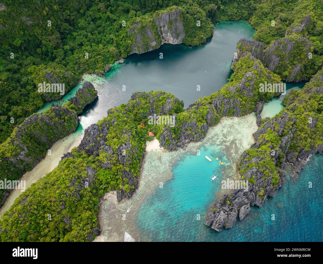 Big and Small Lagoons with kayaks over clear water. Miniloc Island. El ...