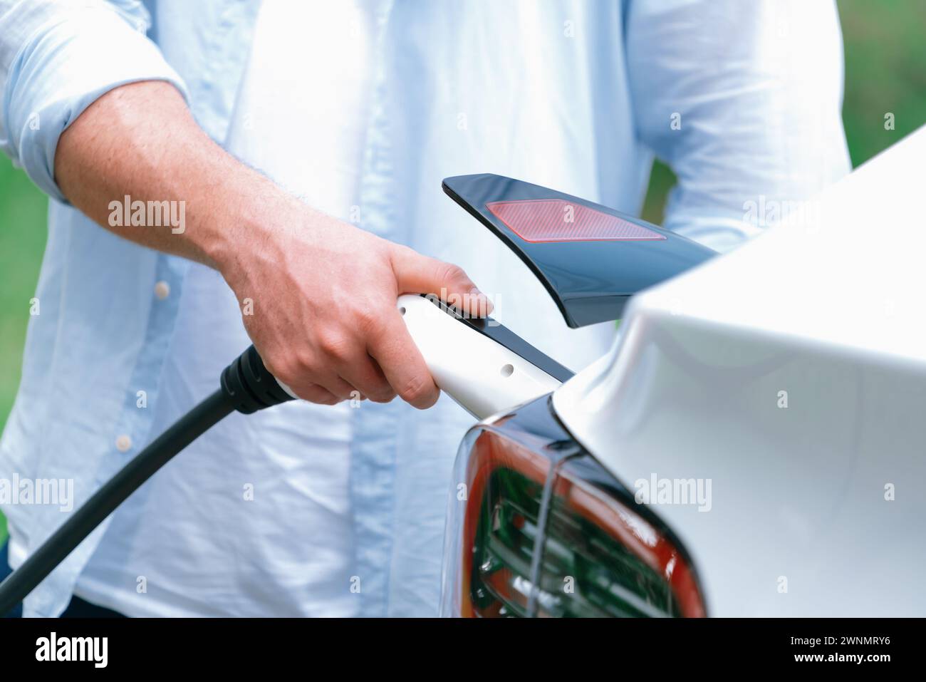 Closeup hand insert and EV charger to recharge EV car's battery from ...