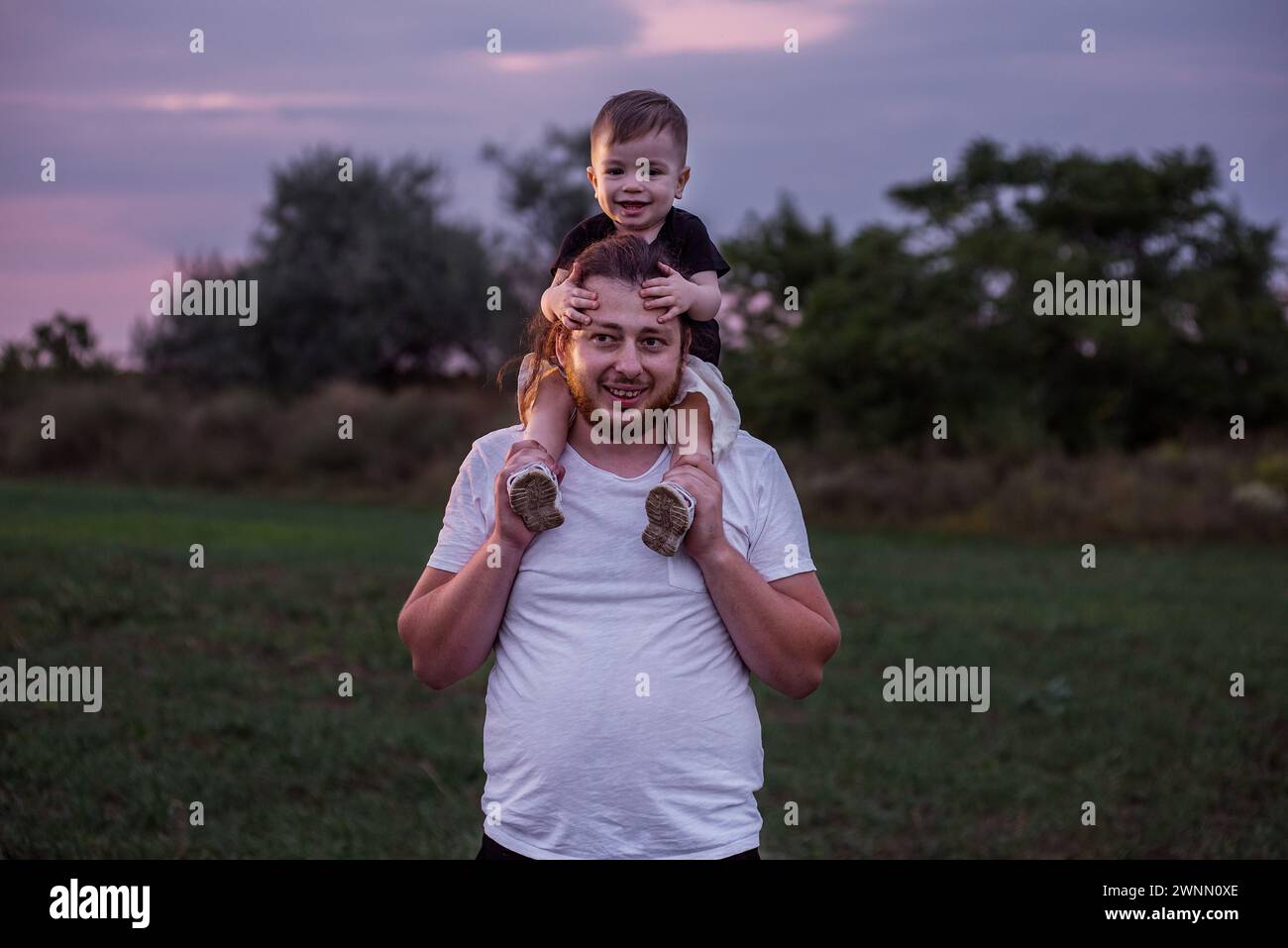 Diversity father with beard carrying son on shoulders shares tender ...