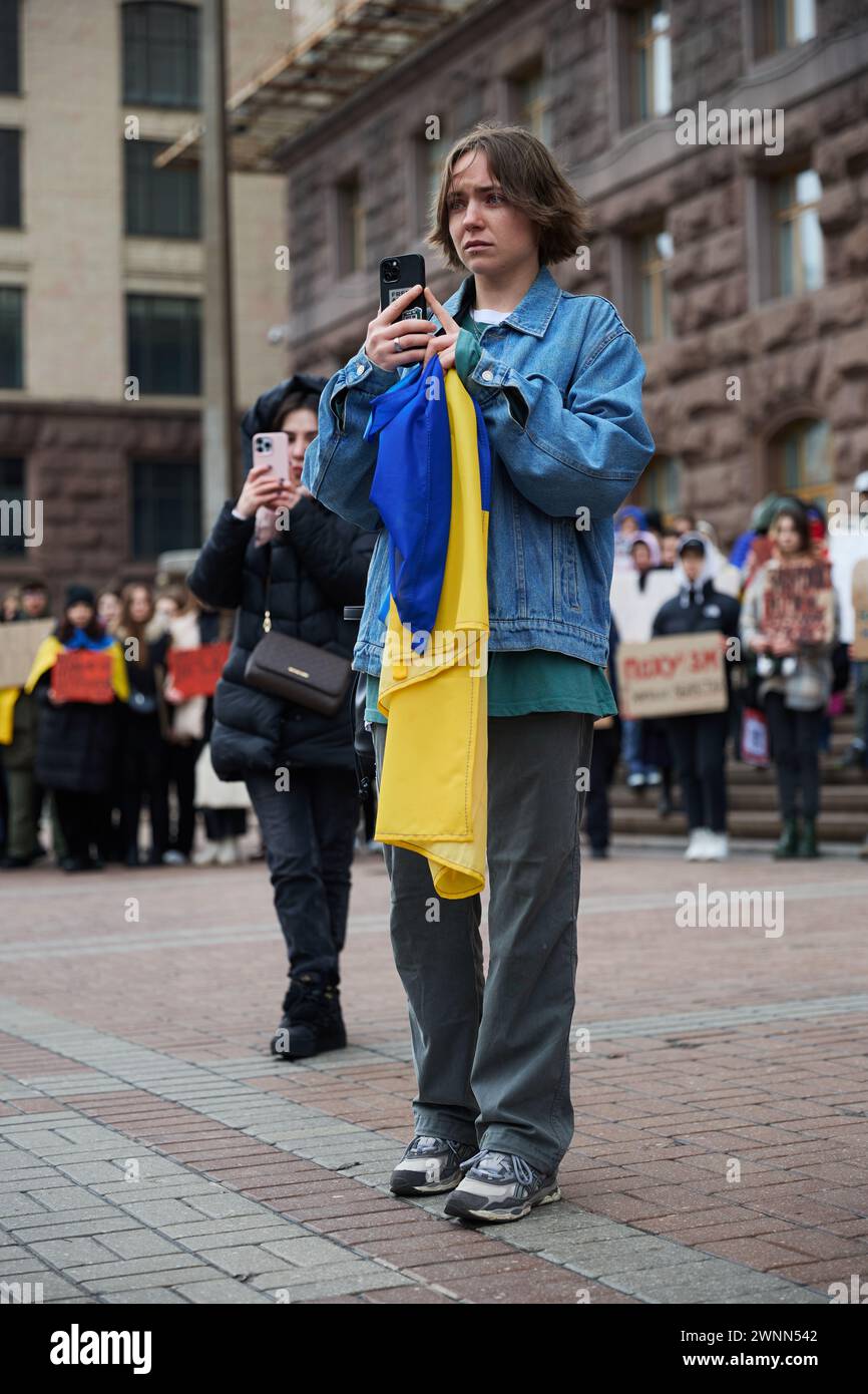 Emotional Ukrainian female filming the rally with a smartphone. Public ...