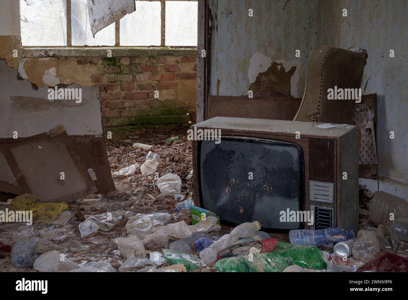 discarded dumped television amongst empty plastic bottles inside ...
