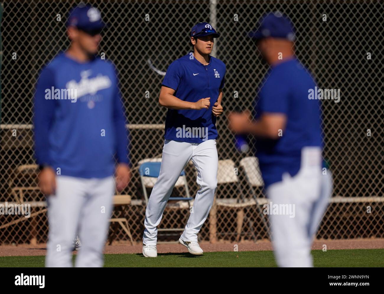 Los Angeles Dodgers' Shohei Ohtani jogs on to a practice field as he ...