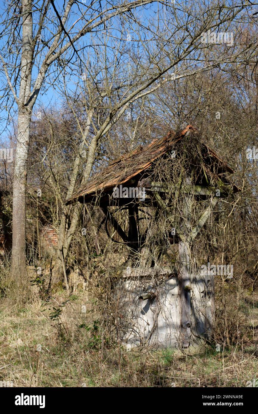 old water well in garden of derelict abandoned wreck of crumbling ...