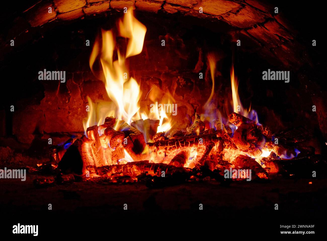 Burning logs are surrounded by vibrant, moving flames of fire Stock ...