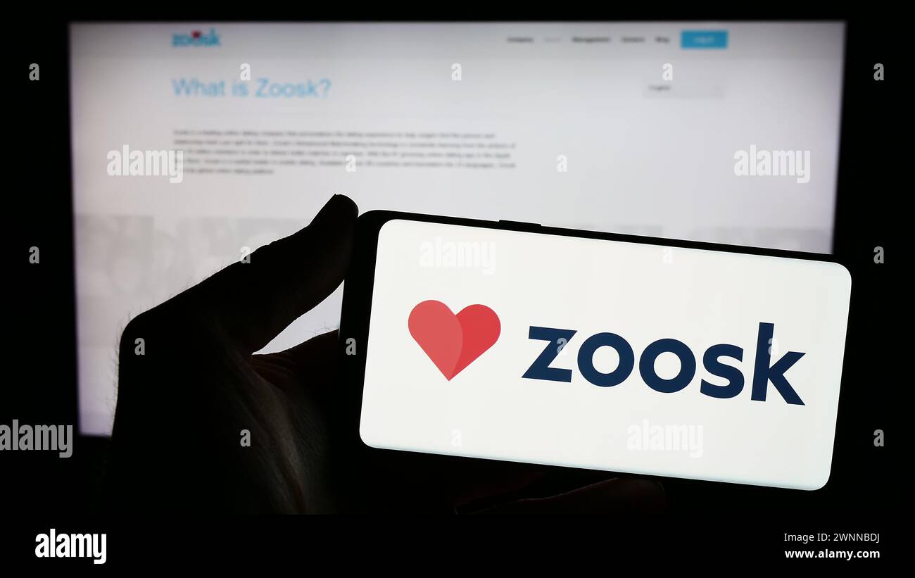 Person holding smartphone with logo of online dating platform company ...