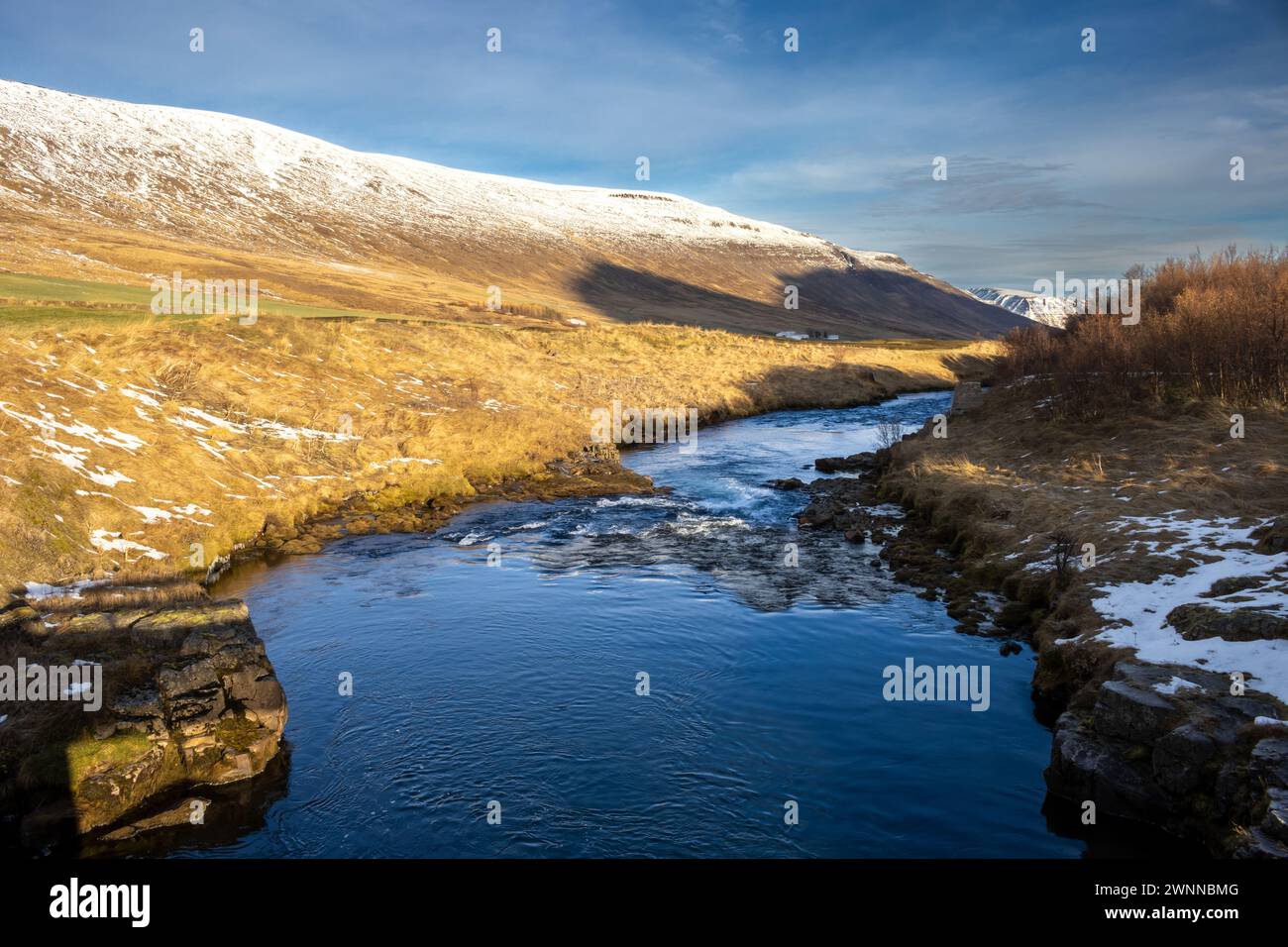 Indigo blue color of a river, so typical at the island. Small hills on ...