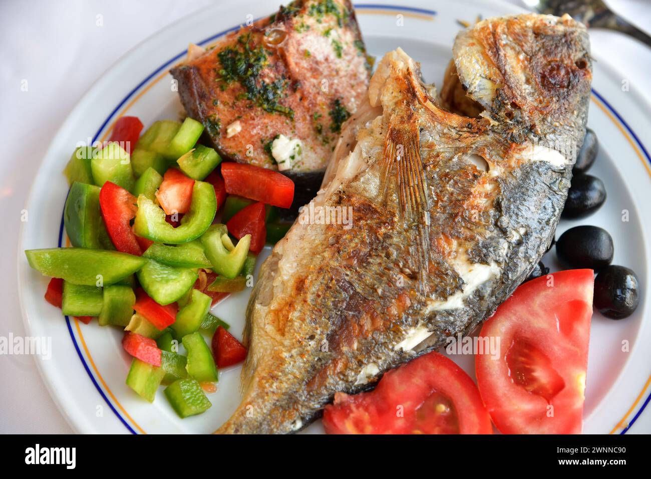Fried river fish carcass with vegetables Stock Photo - Alamy