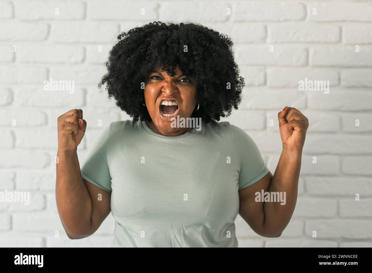 Angry african american woman screaming on brick background. Bad ...