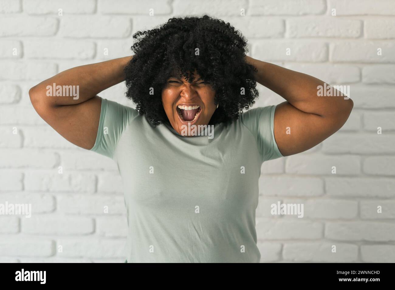Angry african american woman screaming on brick background. Bad ...