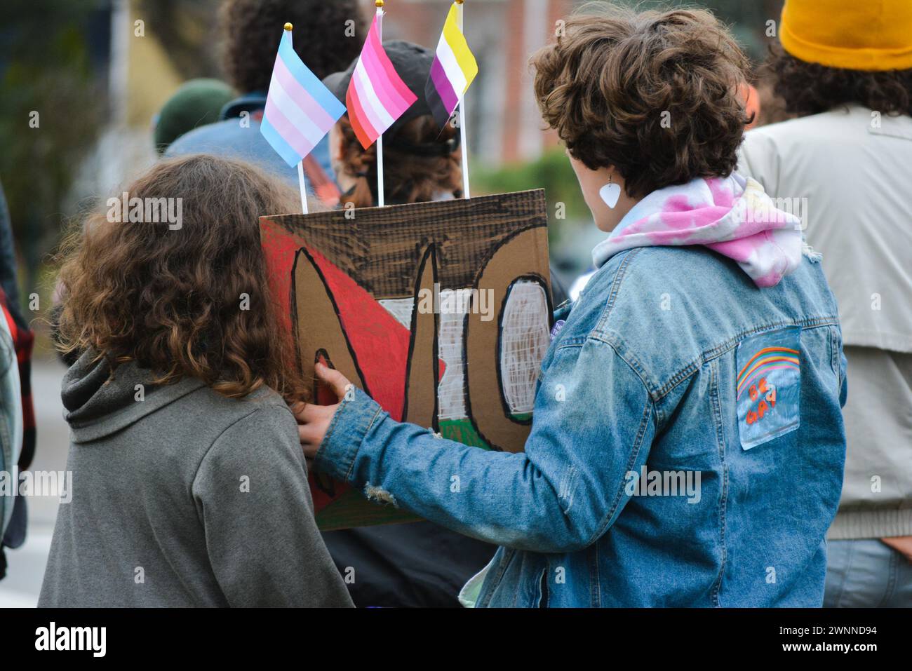 Two People with a sign protesting the violence in Gaza Stock Photo - Alamy