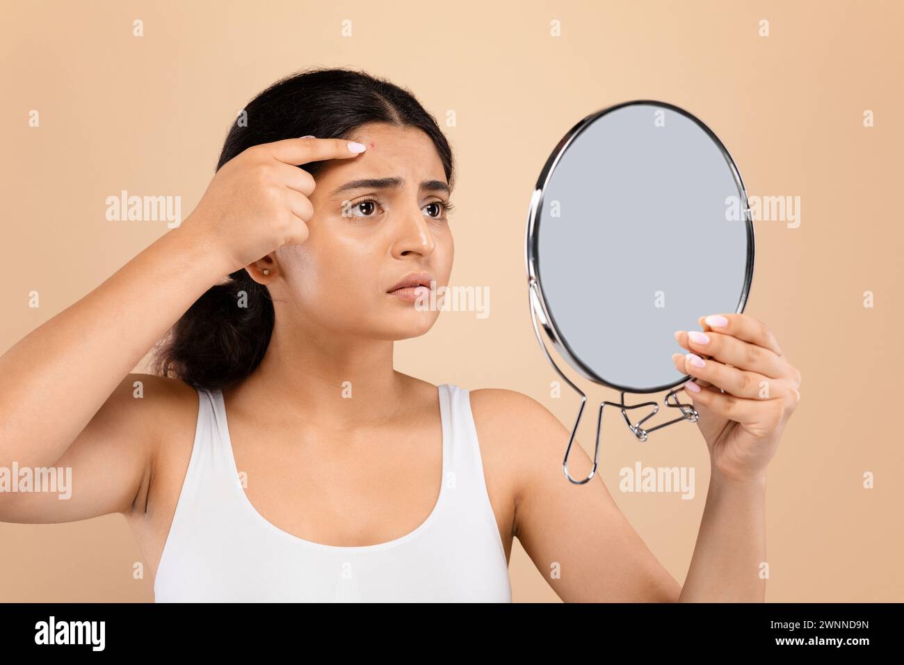 Young woman mirror face inspecting hi-res stock photography and images ...