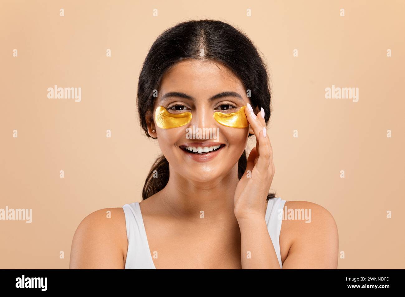 Happy beautiful young indian woman applying golden eye patches Stock ...