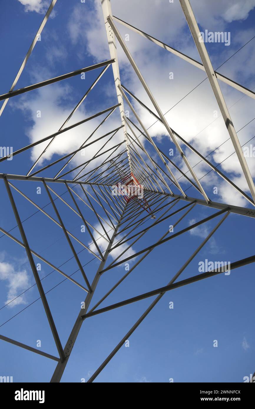 High Voltage Electricity Grid Pylon seen from below and white clouds ...